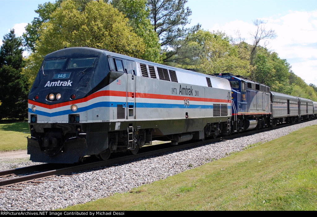 Amtk Heritage P-42DC #145 leads a northbound with NCDOT F-59PH #1893 across Halligan Park Rd.
